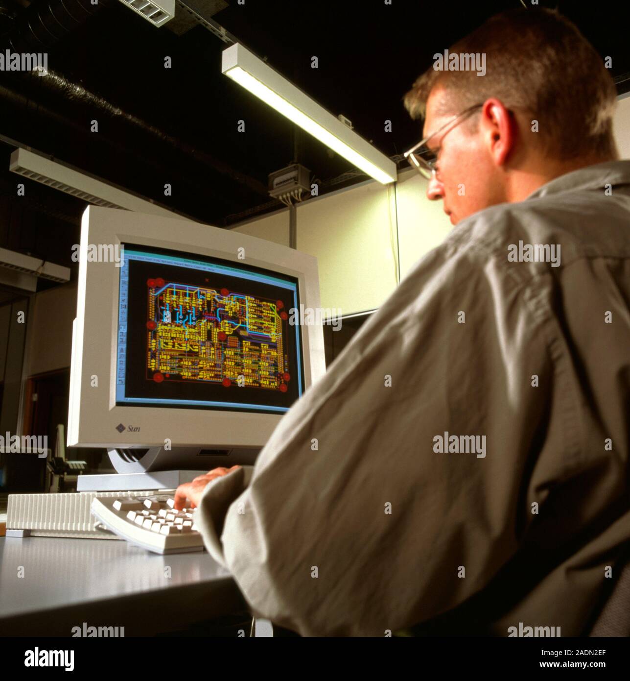 POSED BY MODEL. Computer-aided circuitry design. Man uses a computer to ...