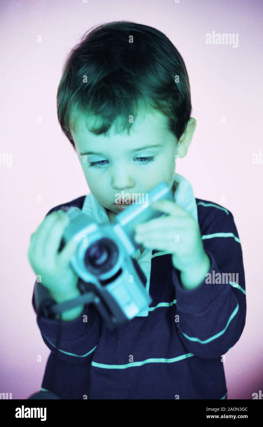 Boy with video camera. Young boy looking into the viewfinder of a video ...
