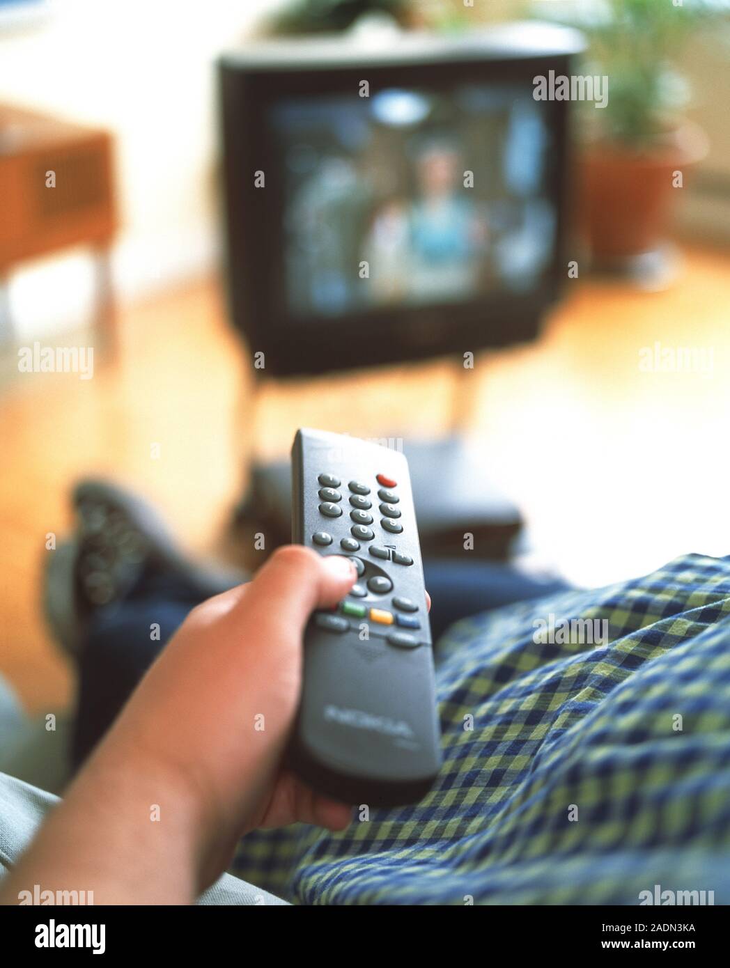 Remote control. Man using a remote control to operate a television ...