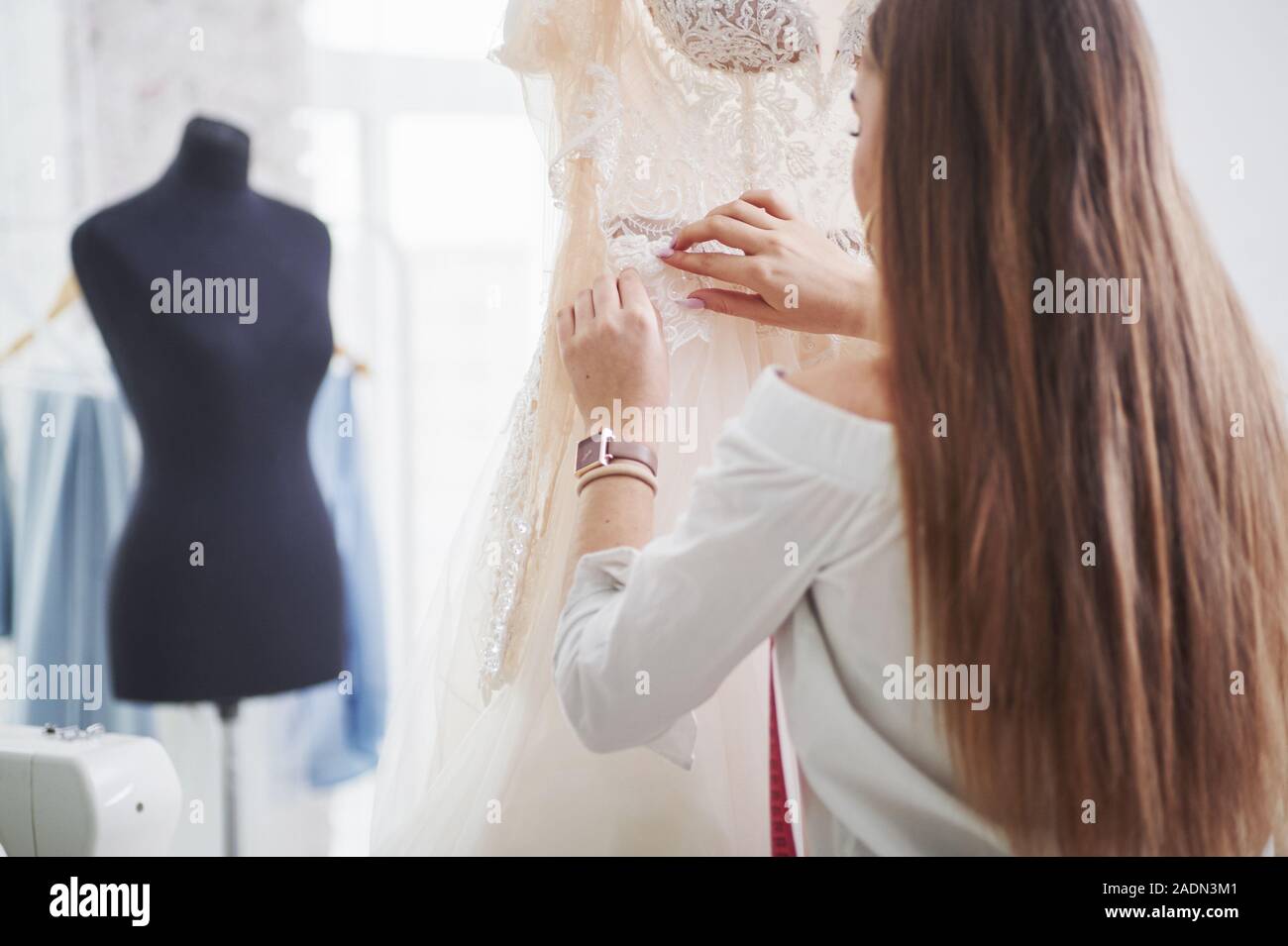 Checking details. The process of fitting the dress in the studio of ...
