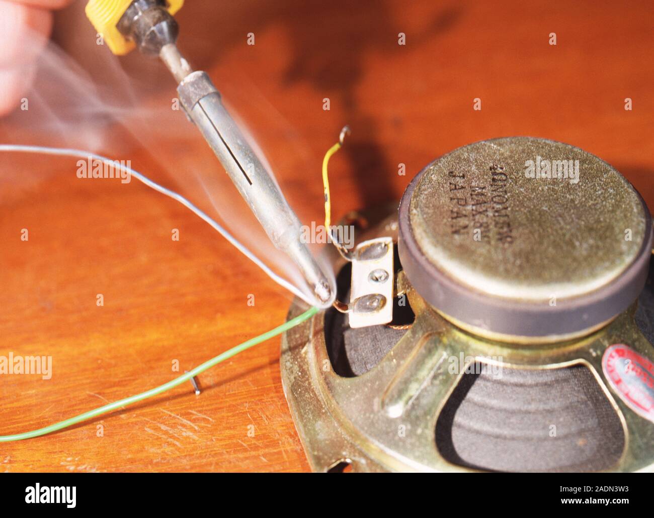 Soldering a loudspeaker. Wires being soldered onto the connectors of an ...