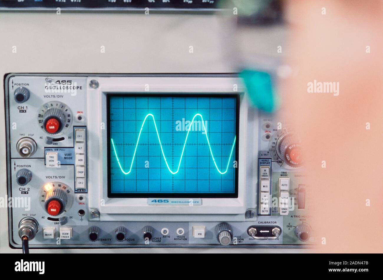 MODEL RELEASED. Oscilloscope showing a sine wave. This device produces ...