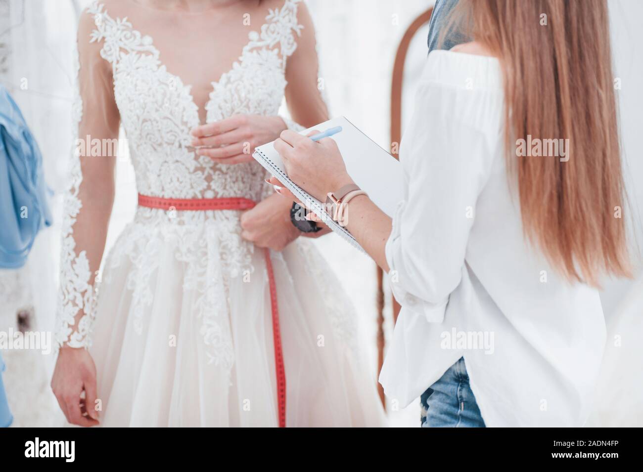 Making notes. The process of fitting the dress in the studio of hand ...