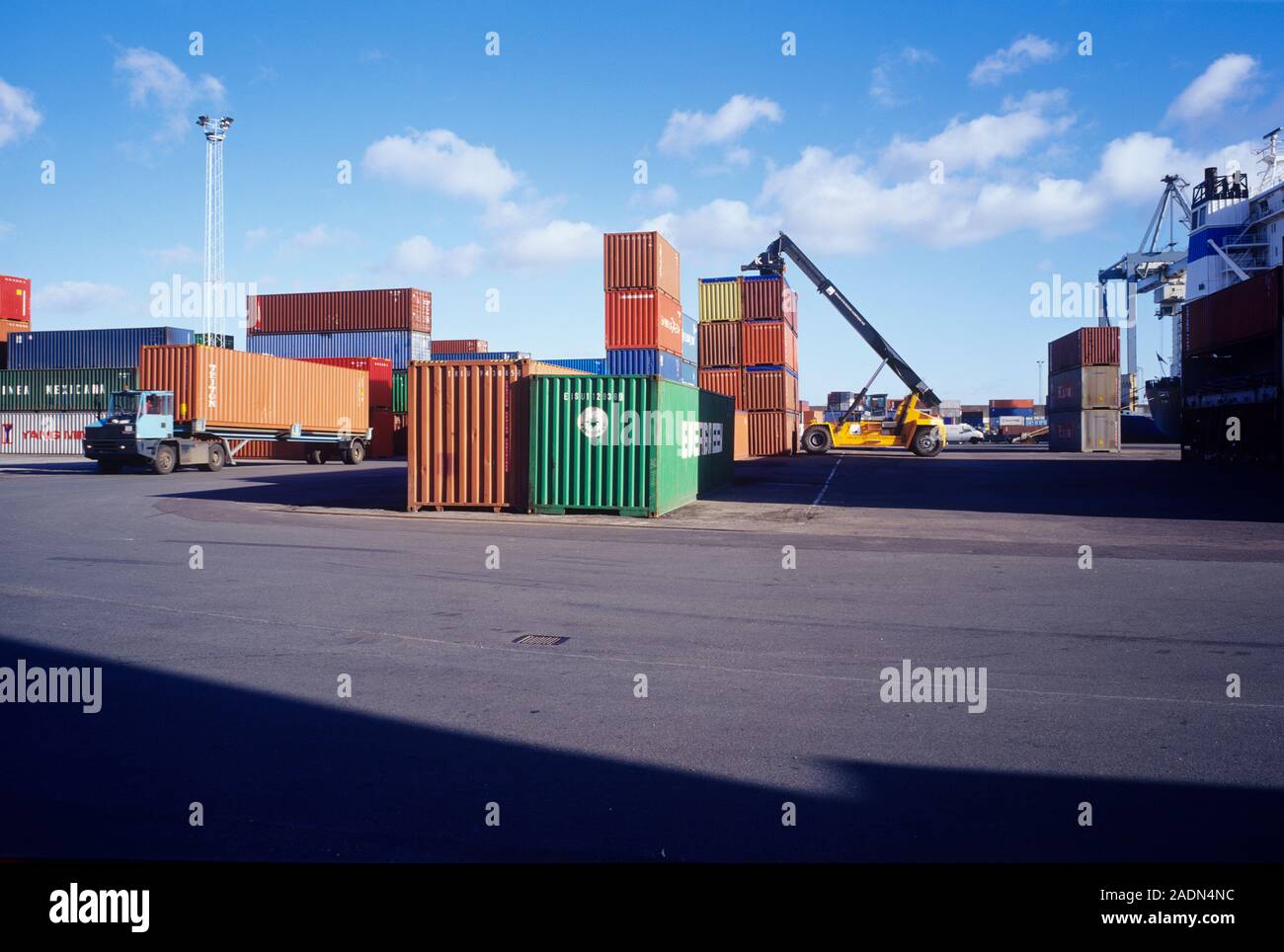 Container port. Stacks of containers and a vehicle moving them ...