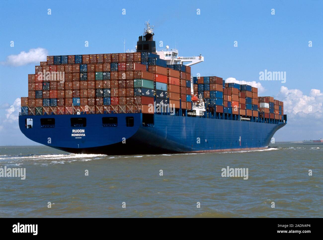 Container ship at sea. The containers, stacked on the deck of the ship ...
