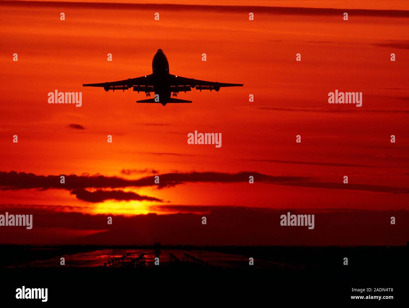 Sunset departure. A Boeing 747 'Jumbo Jet' climbs away from an airport ...