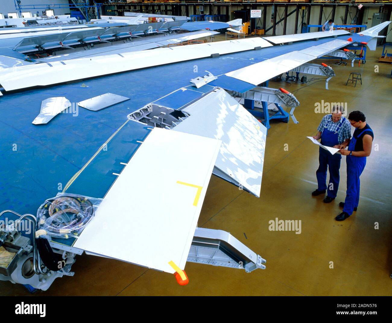 Aircraft construction. Technicians studying design plans whilst ...