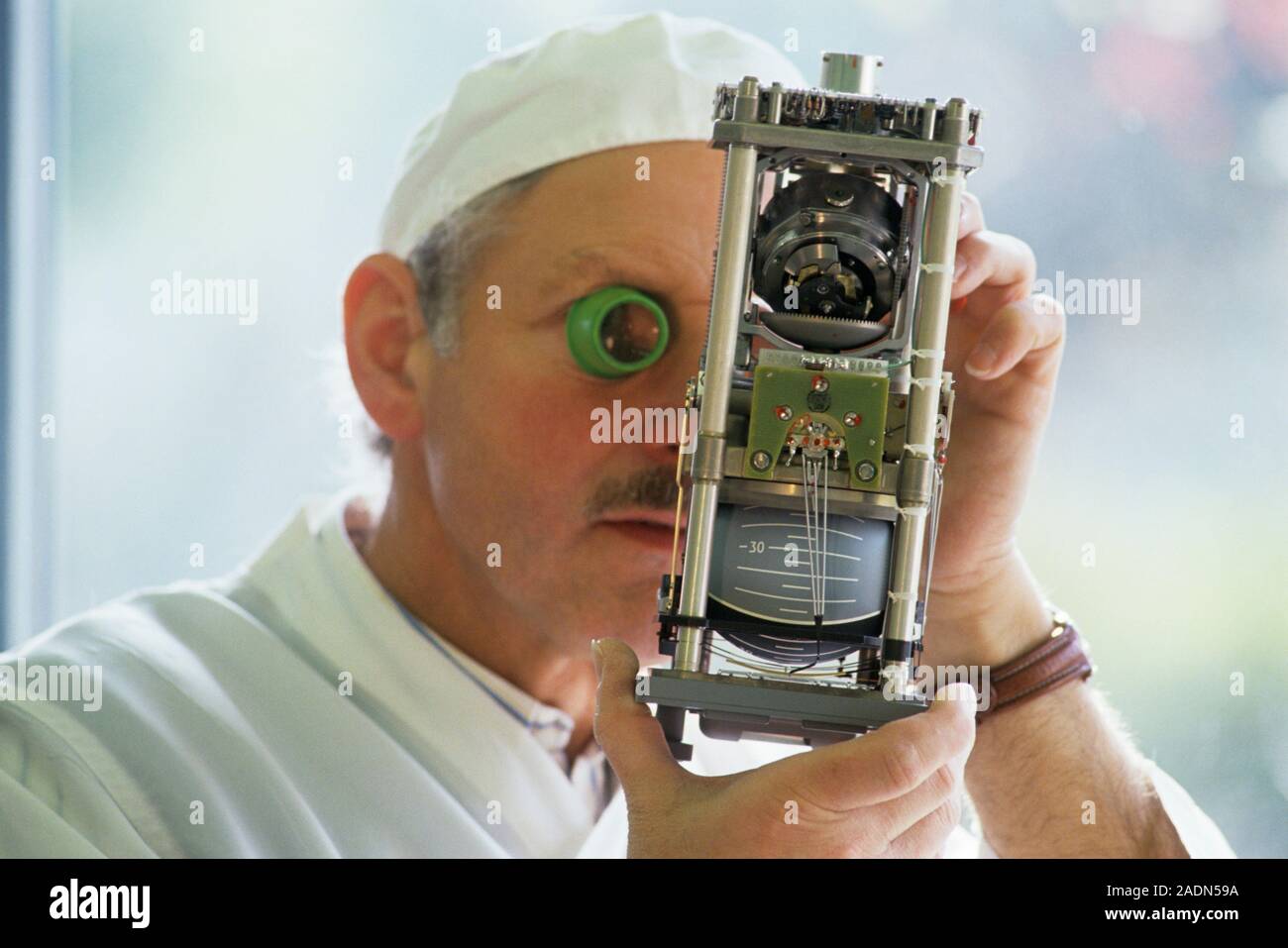 MODEL RELEASED. Gyroscope assembly. Mechanic assembling a gyroscope for ...