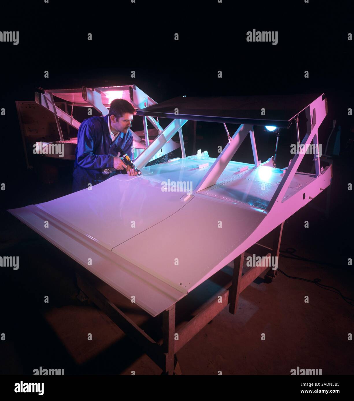 Aircraft manufacturing. Worker constructing an airplane component. The ...