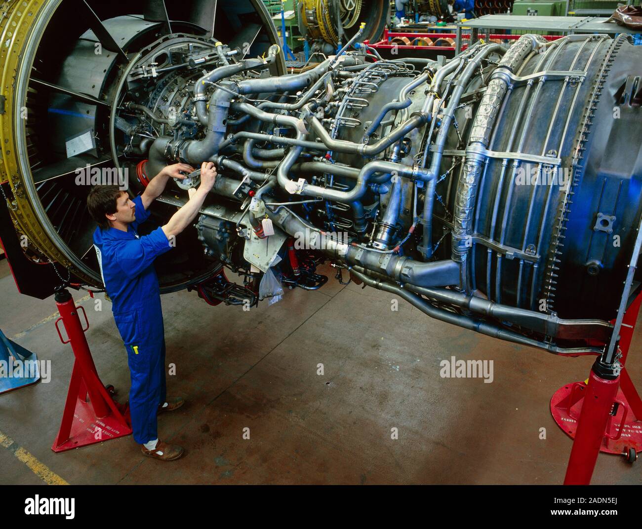 MODEL RELEASED. Aeroplane engine assembly. Mechanic assembling an ...