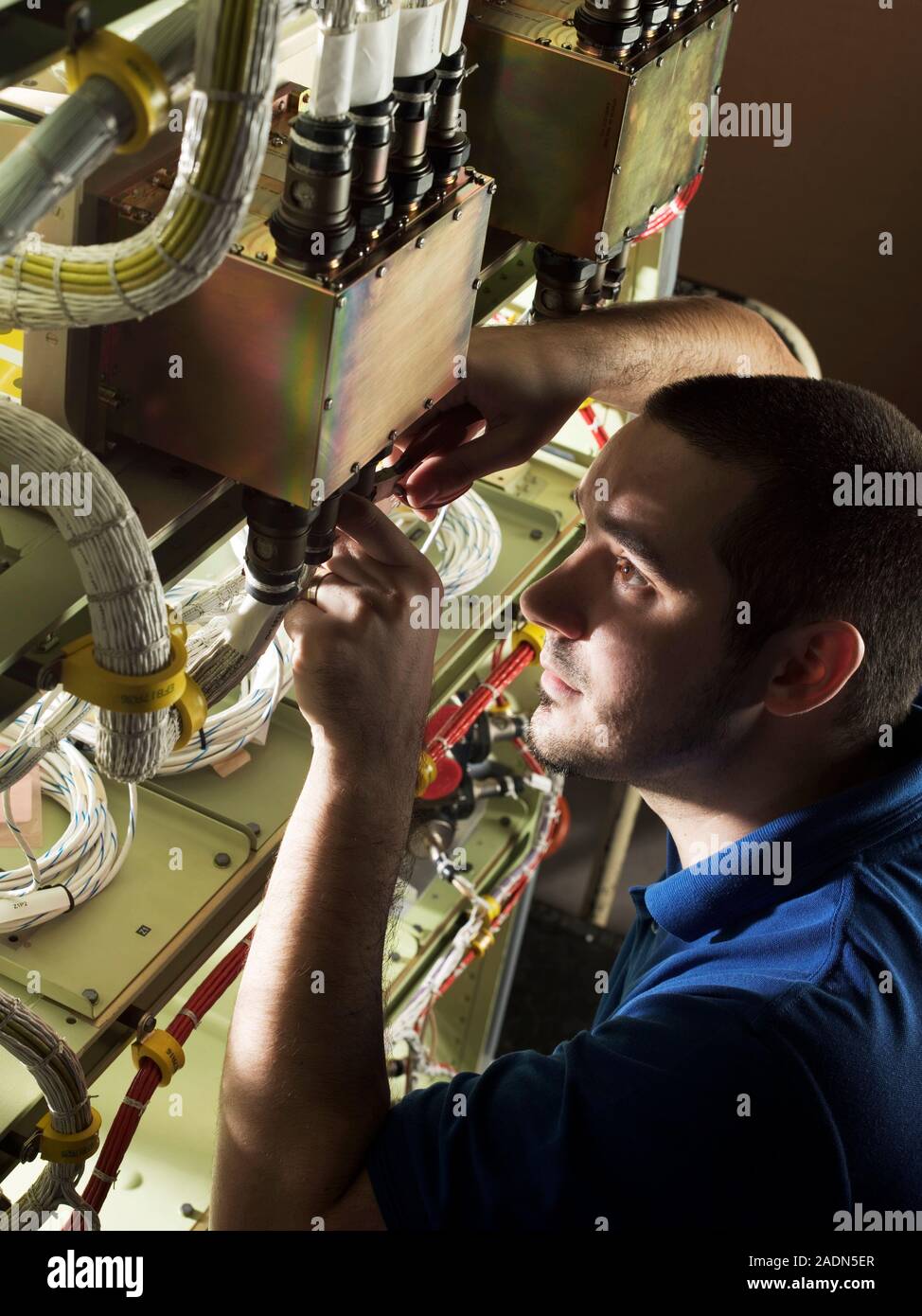 Aircraft construction. Aviation electronics technician attaching wiring ...