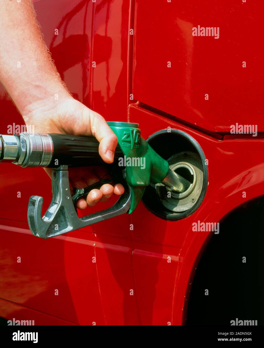 Filling petrol tank. Motorist's hand filling the petrol tank of a car ...