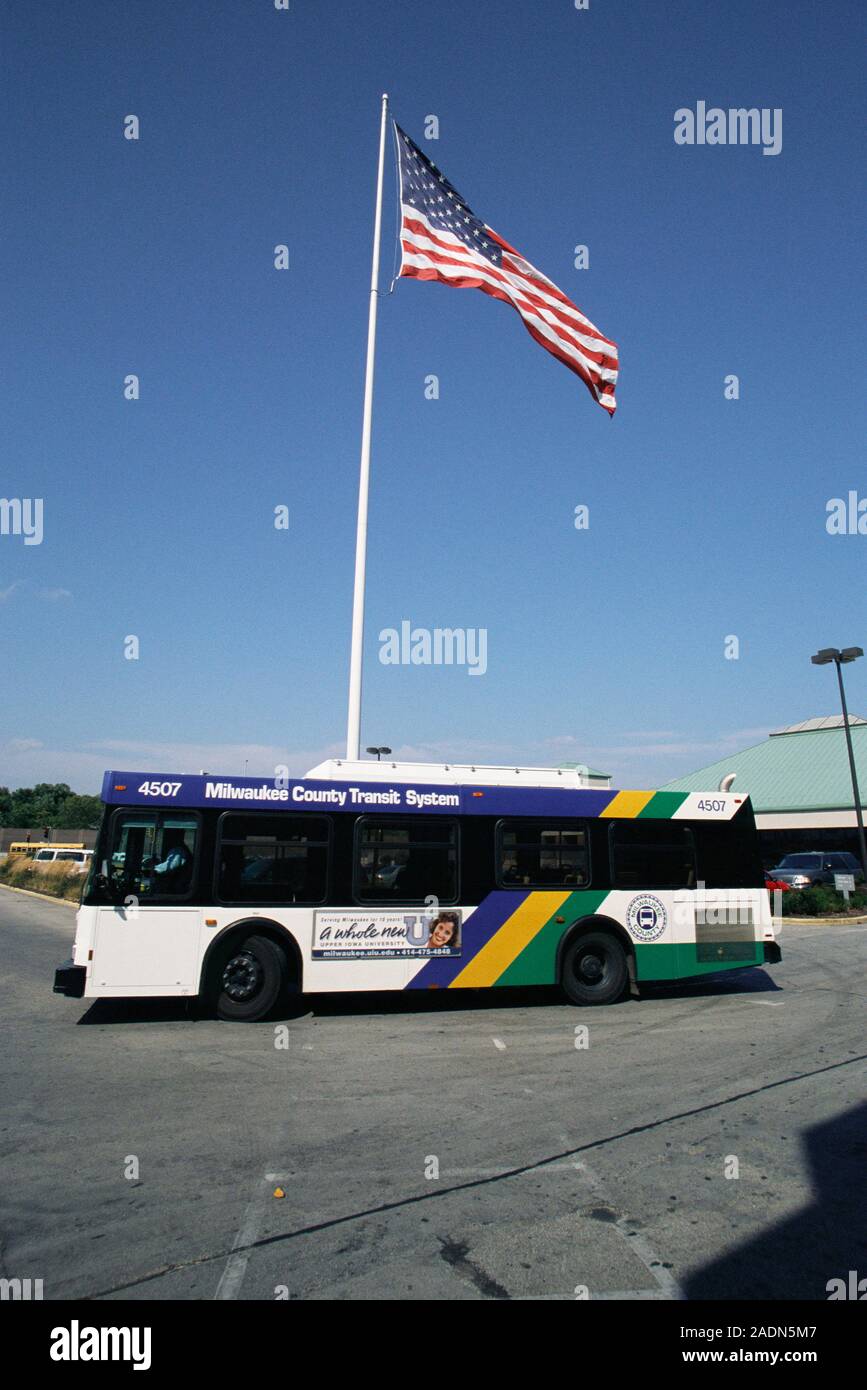 Bus driving past a US flag. The bus is part of a public transport ...