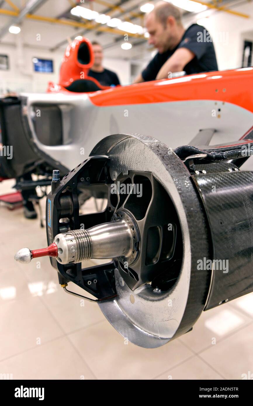 Racing car wheel hub. Mechanics working on a Formula One racing car in ...