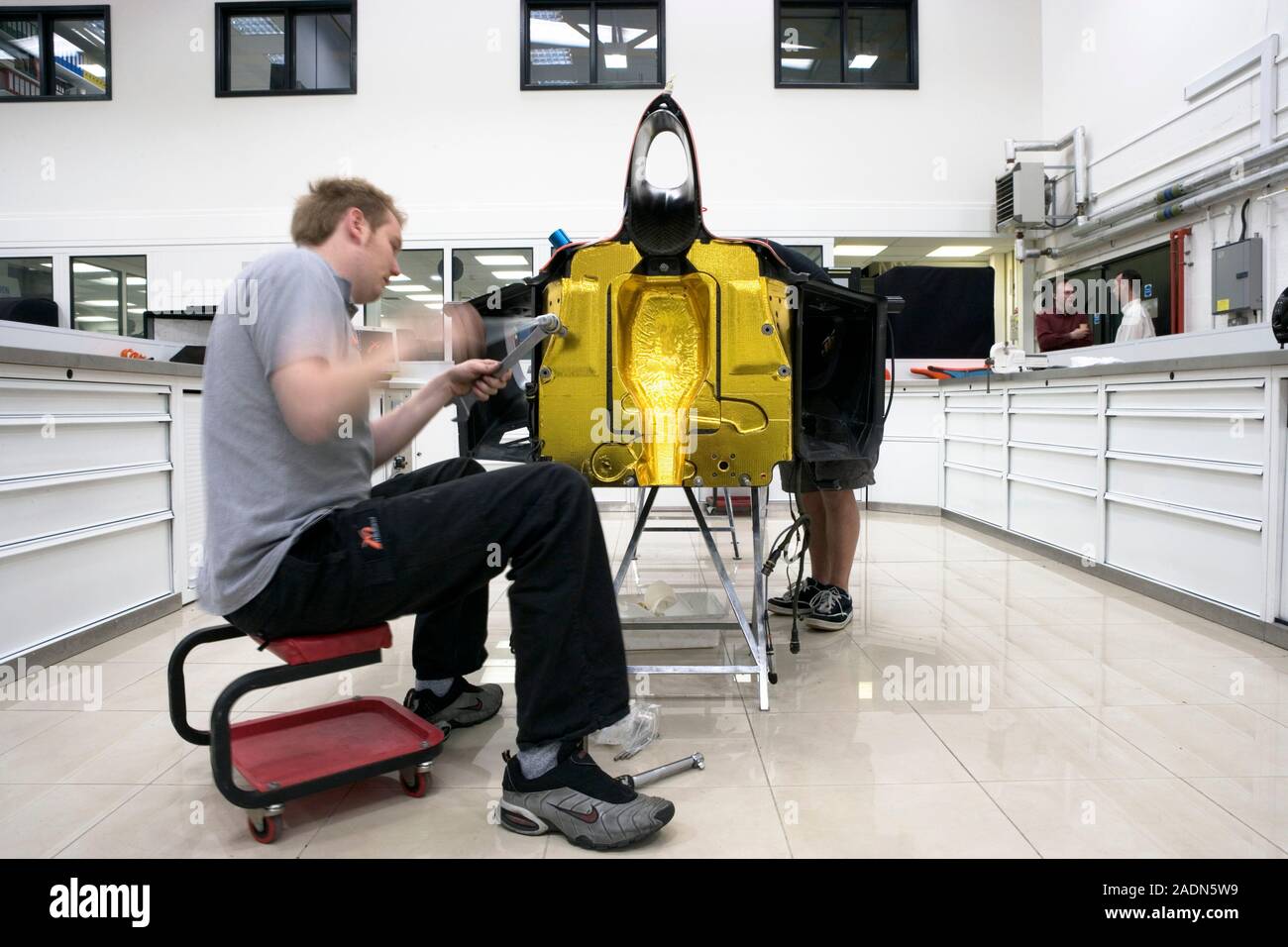 MODEL RELEASED. Racing car preparation. Mechanic tightening a bolt in ...