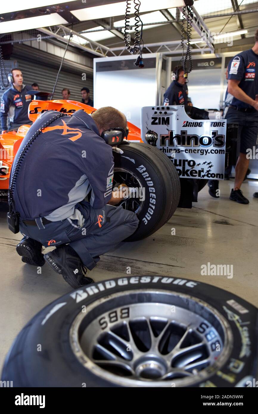 Formula One car being prepared. Mechanics changing the wheel on a ...