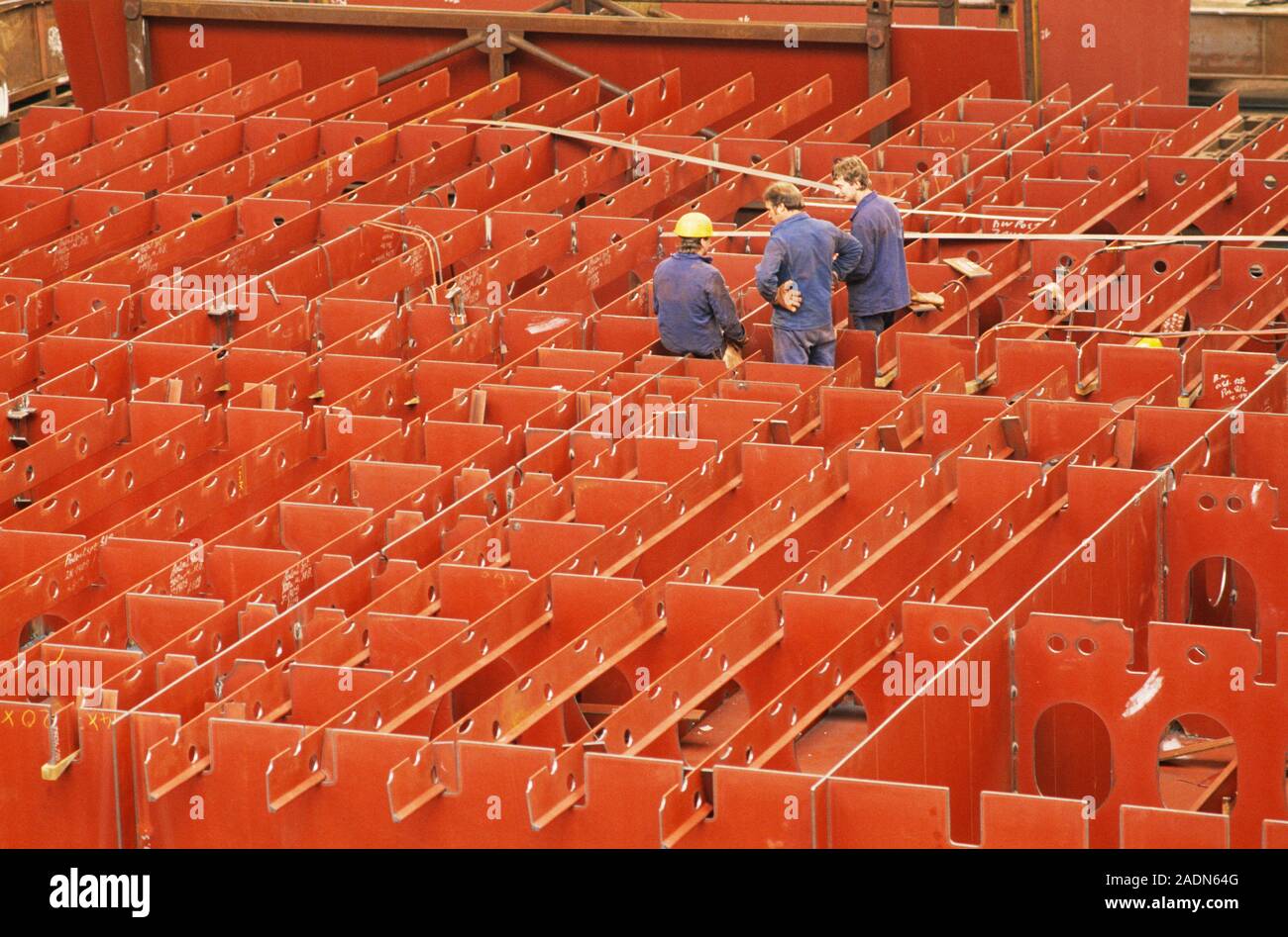 Shipbuilding. Workers inspecting the prefabricated segments of a ship's ...