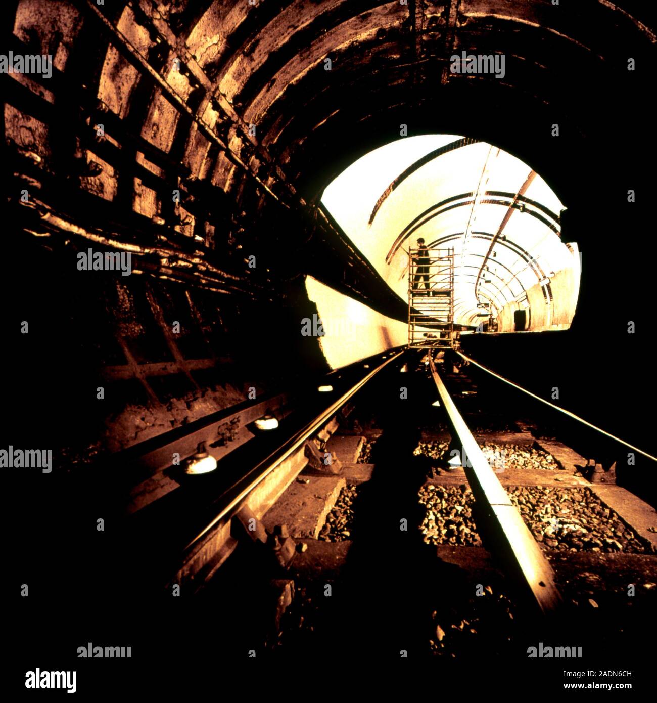 Underground maintenance. Worker cleaning the wall of an underground ...