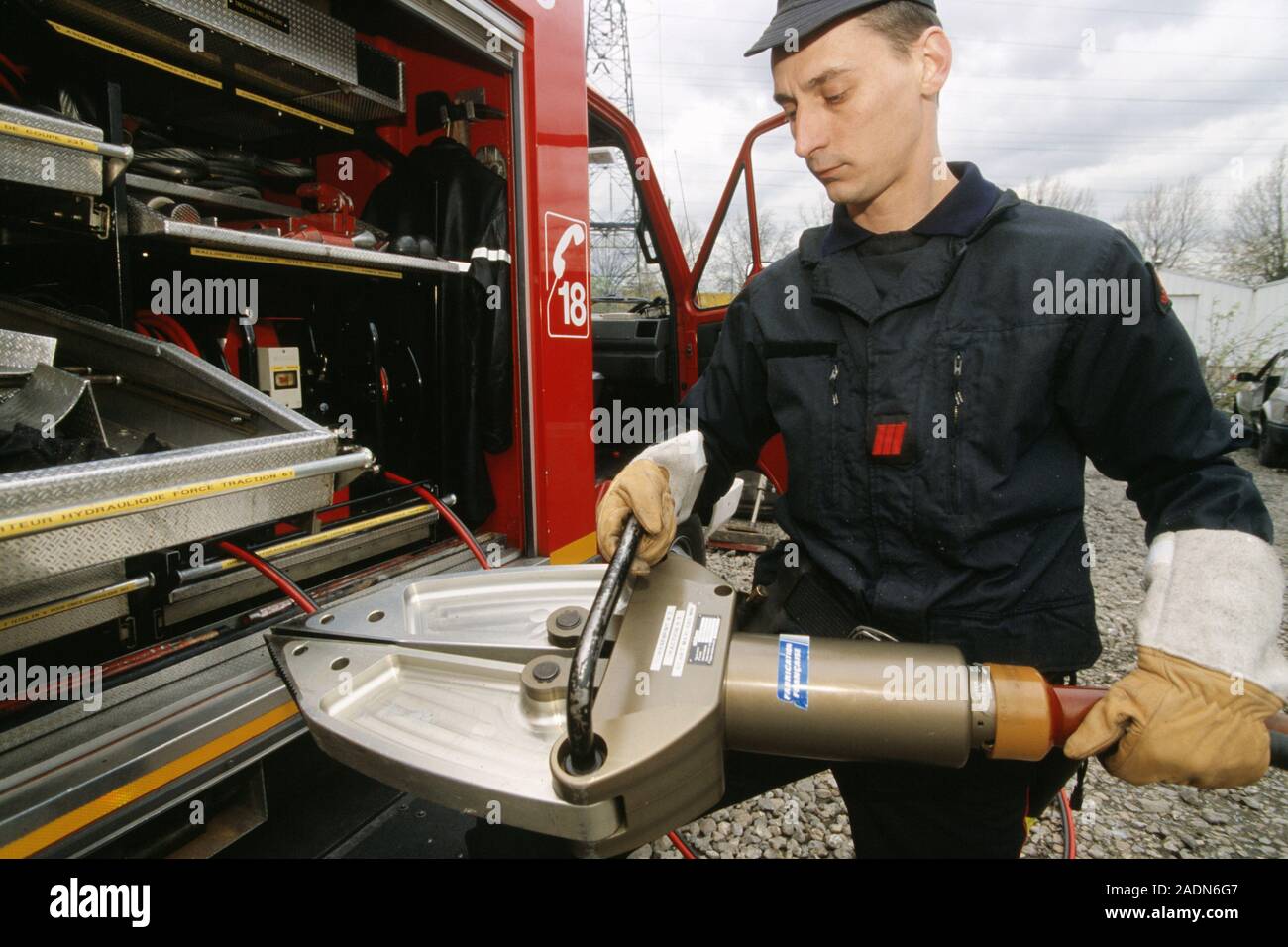 Hydraulic cutters. Firefighter holding hydraulic cutters, which are ...