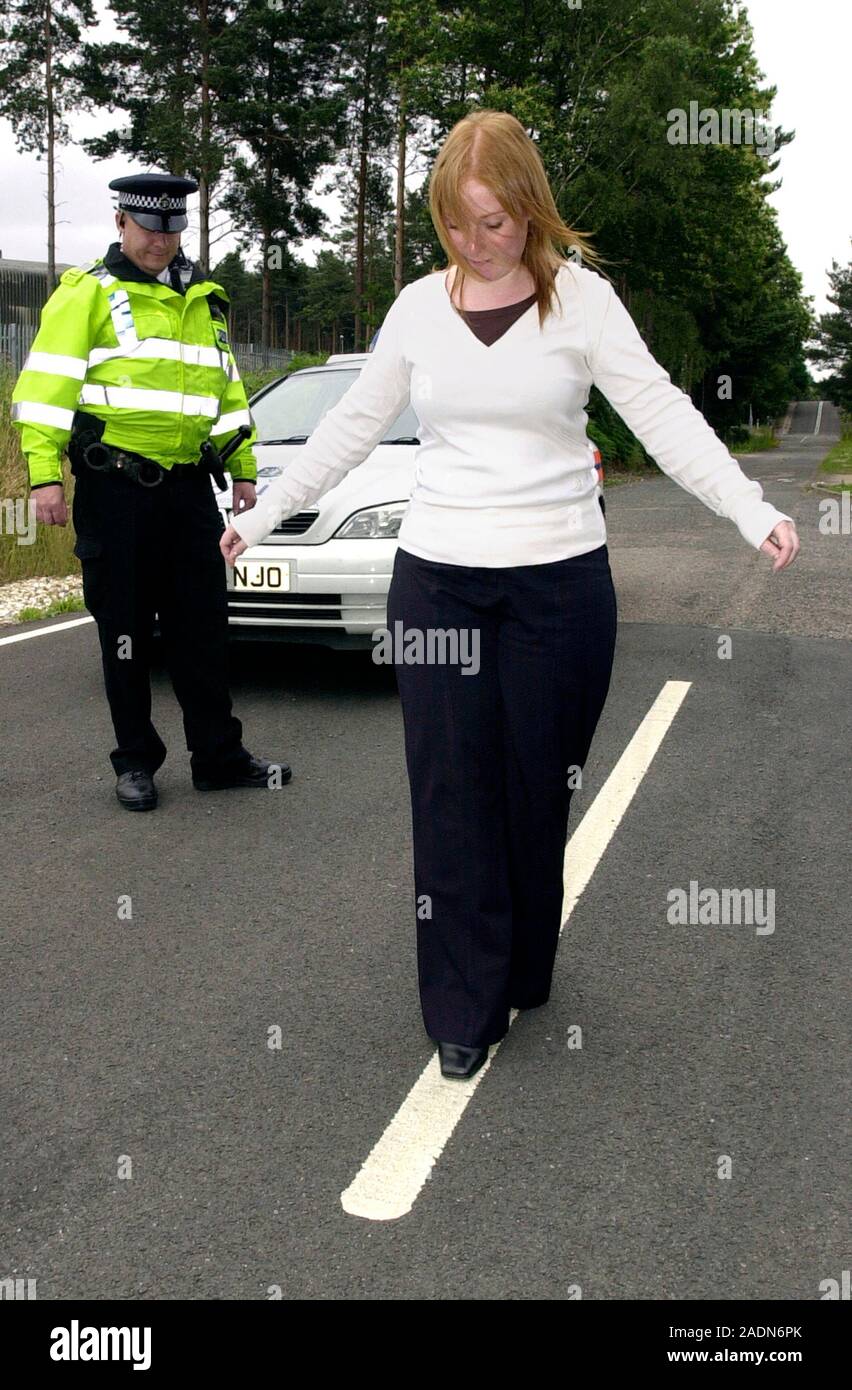 Roadside sobriety test. Police officer watching a driver walk along a ...