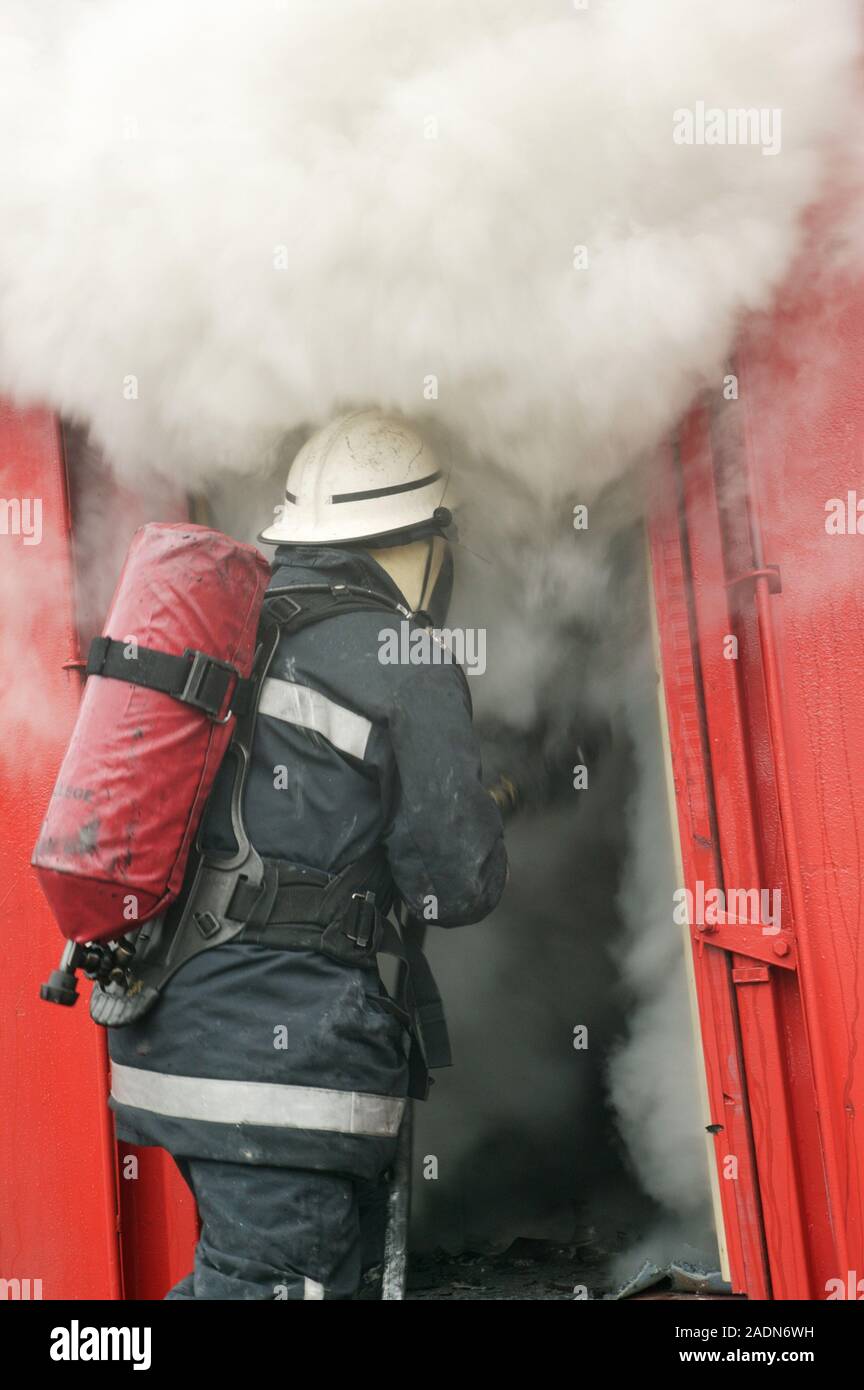 Firefighter entering a smoke-filled building. He is extinguishing a ...