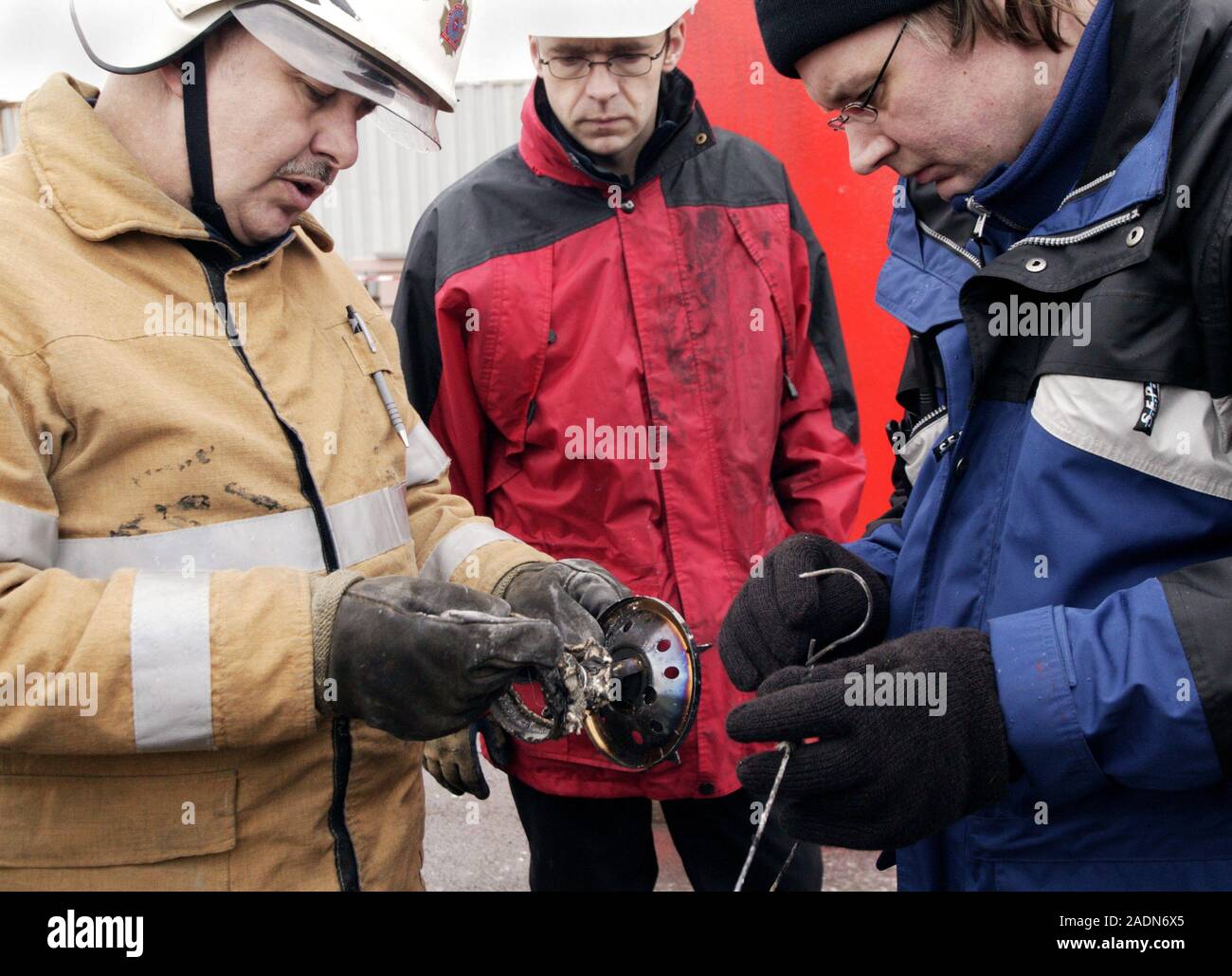Firefighters examining evidence from a house fire. Evidence collected ...