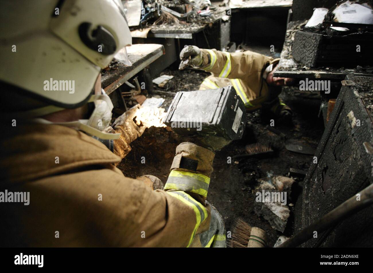 Firefighter inspecting a piece of evidence recovered from a house fire ...