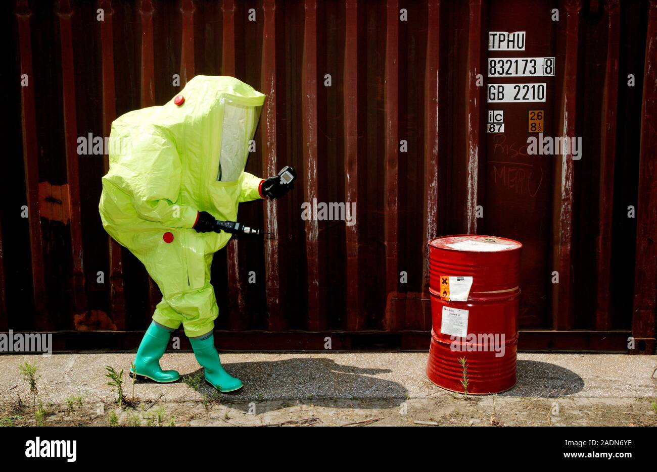 Hazardous waste container. Firefighter approaching a hazardous waste ...