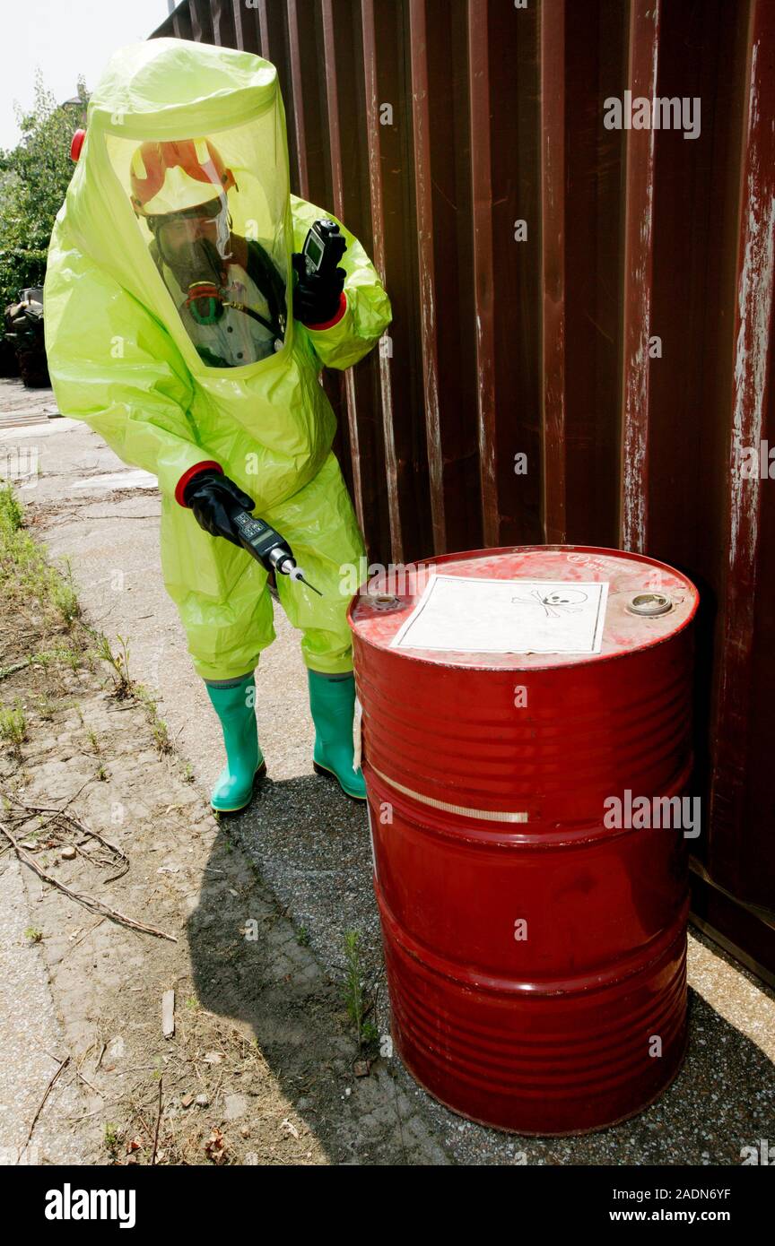 Hazardous waste container. Firefighter approaching a hazardous waste ...
