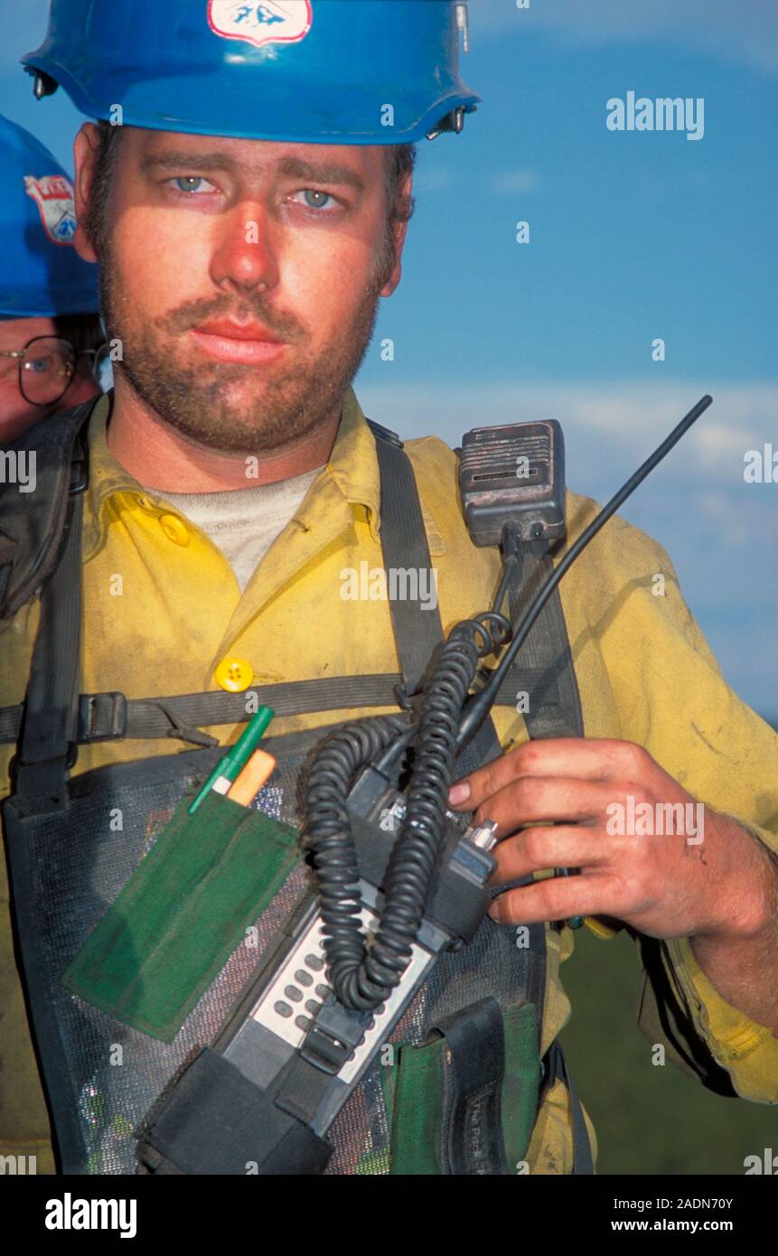 Firefighter. A firefighter adjusts his radio during operations to ...