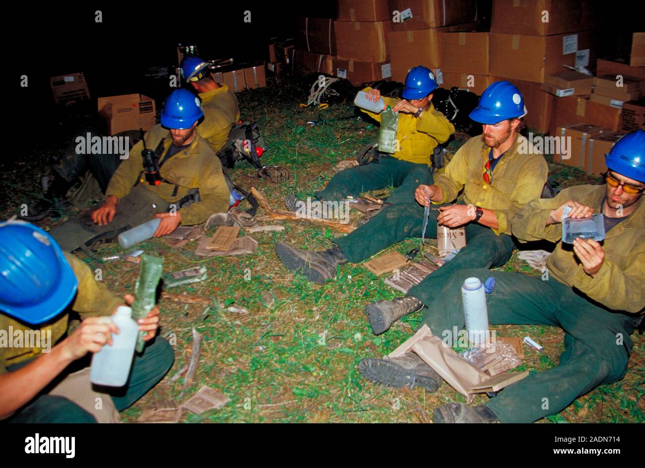 Firefighters, resting and eating at camp during an operation to fight a ...