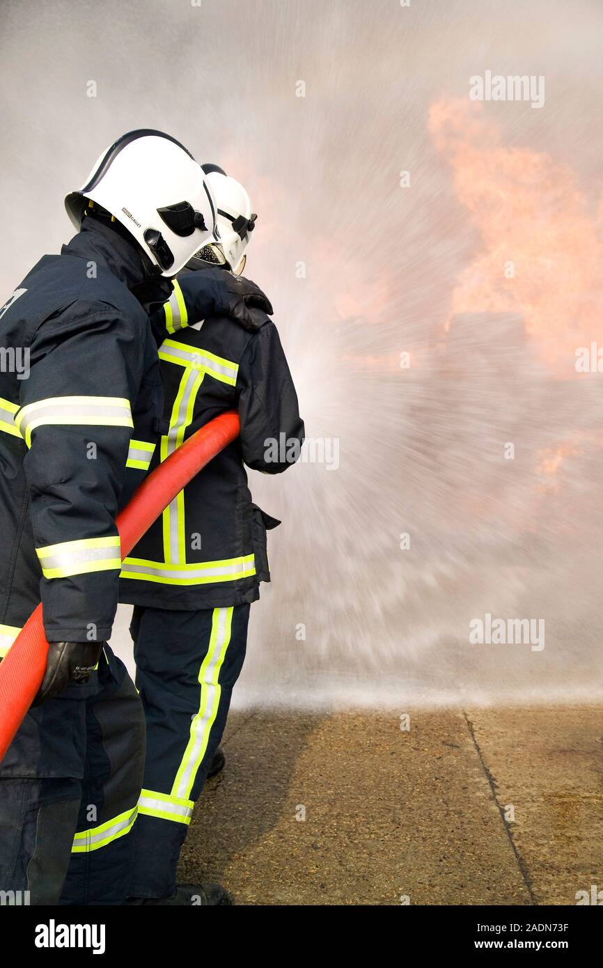 Firefighters extinguishing a fire during a training exercise Stock ...