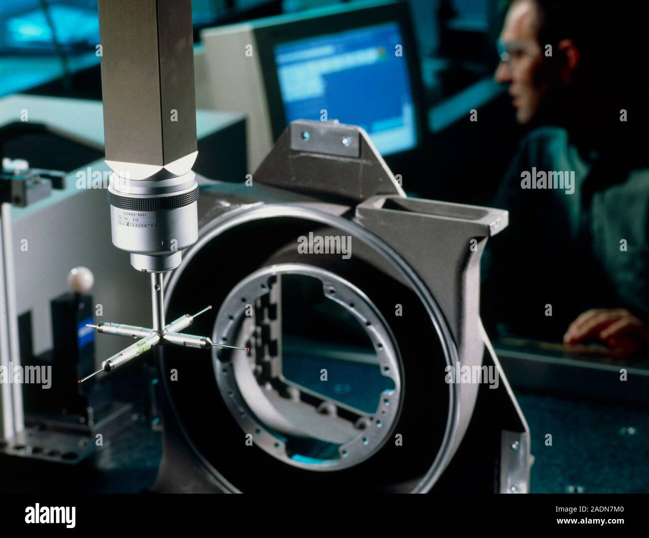 Machine part measurement. Quality control engineer using a three-dimensional measuring device ...