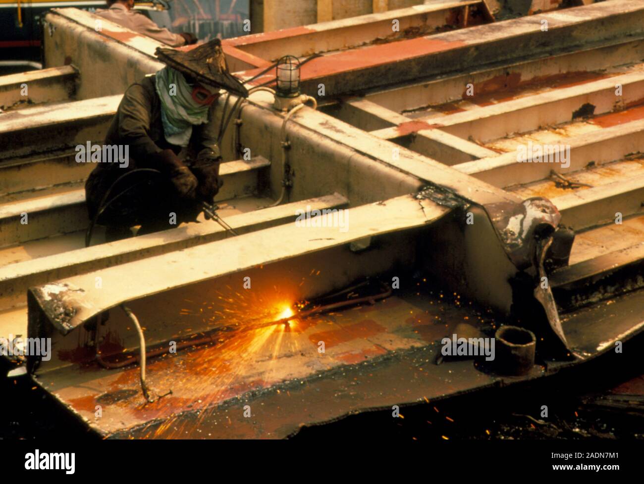 Metal cutting. Worker in protective clothing using an oxyacetylene ...