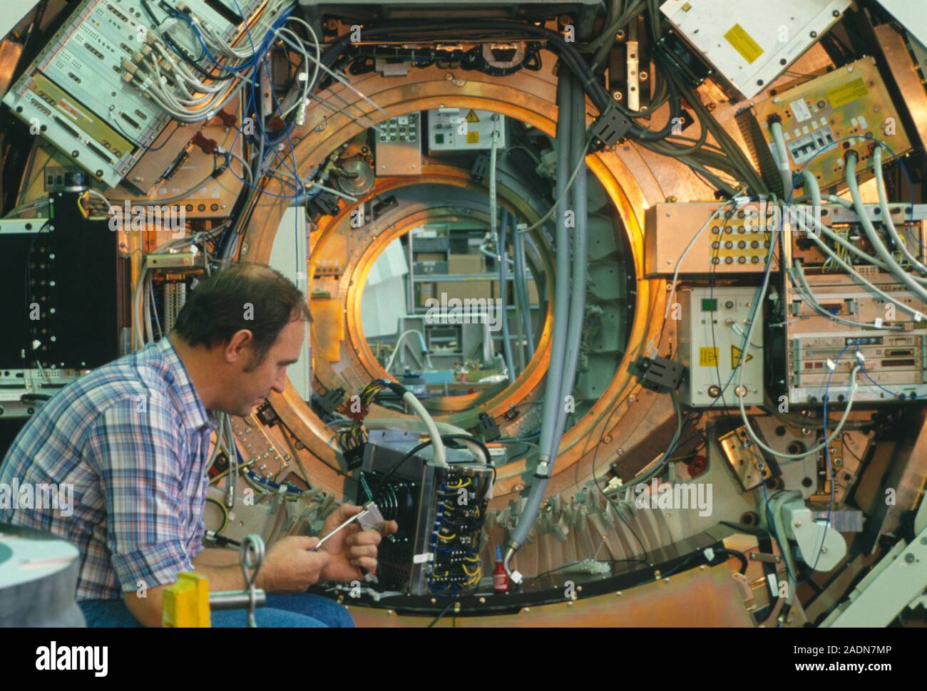 Assembling CT scanner. Engineer assembling a CT (computed tomography ...