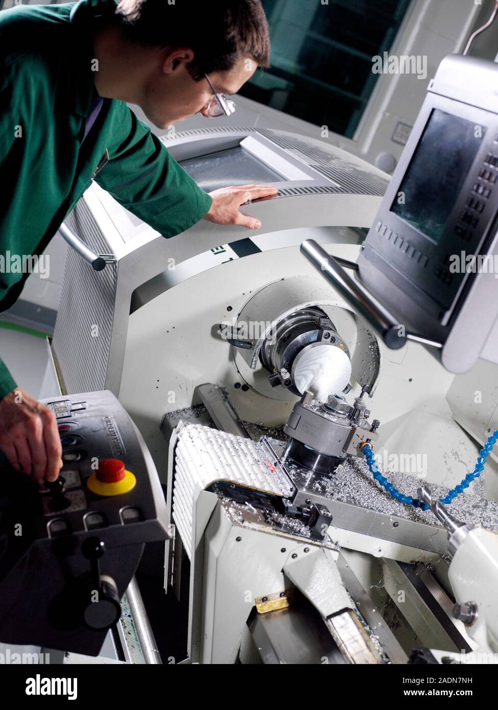 MODEL RELEASED. Metalwork. Metalworker adjusting the controls on a CNC ...