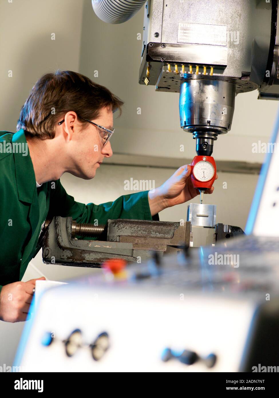 Metalwork. Metalworker using a 3D taster (red) to align the cutter of a ...