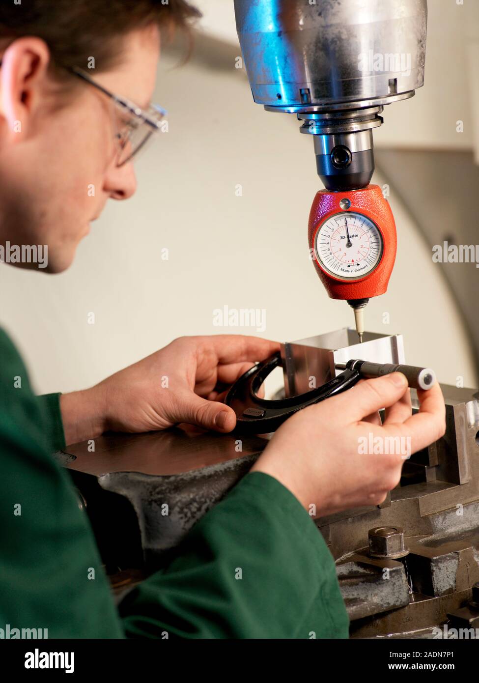 Metalwork. Metalworker clamping a metal box to a CNC (computer ...