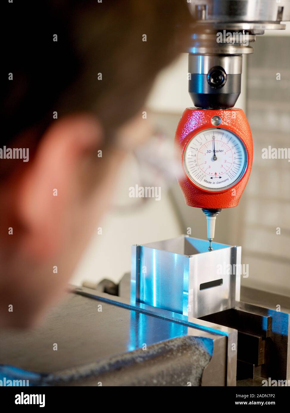 Metalwork. Metalworker using a 3D taster (red) to align the cutter of a ...