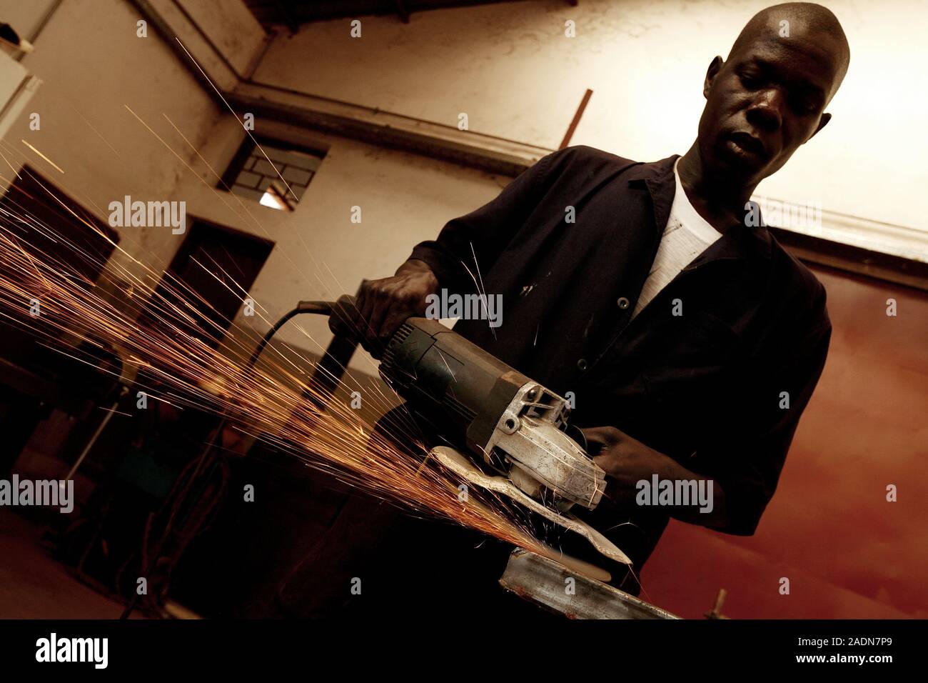 Metal grinding. Metalworker grinding a piece of steel. This is done to ...