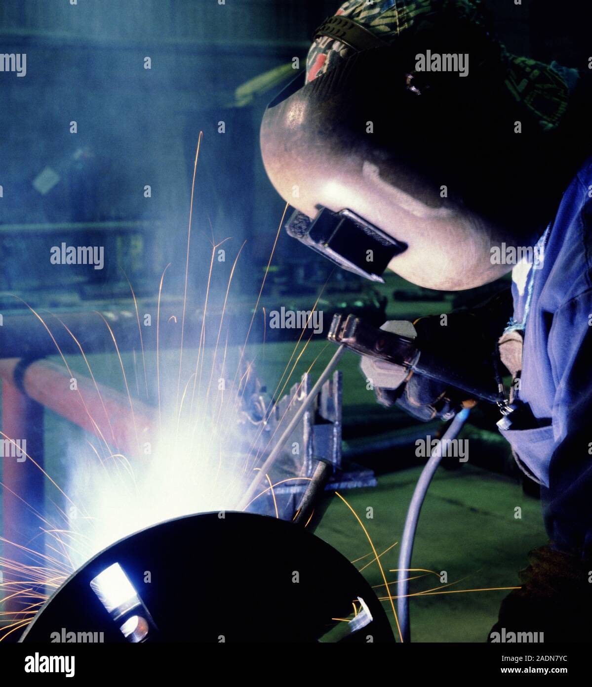 Welder wearing a protective visor. Welding is the process of joining ...