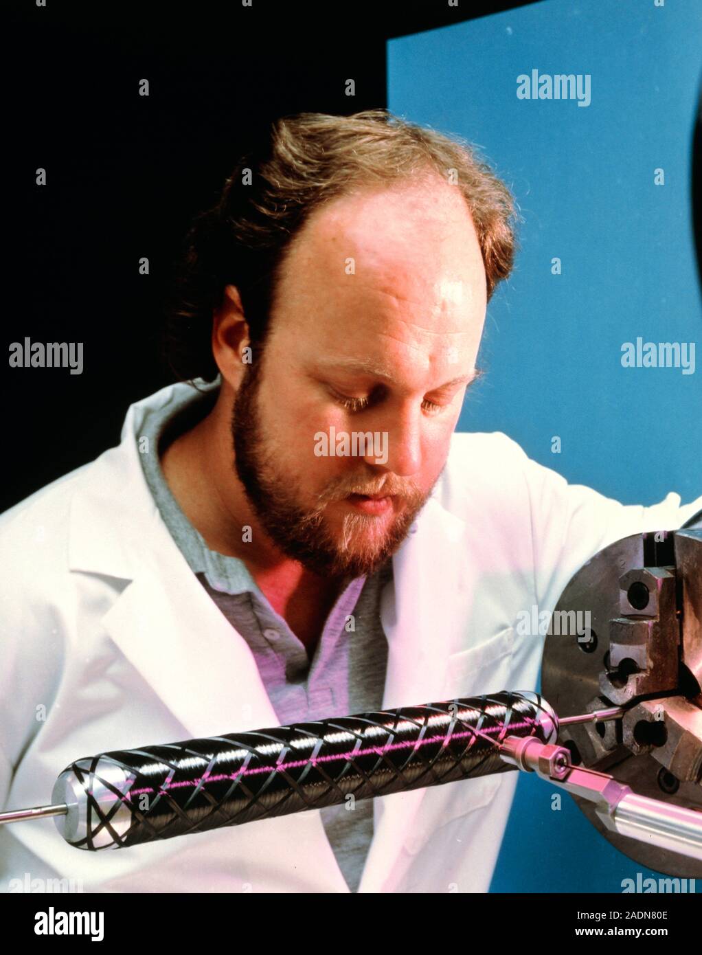 Epoxy-impregnated graphite fibres being wound onto a metal core. This ...