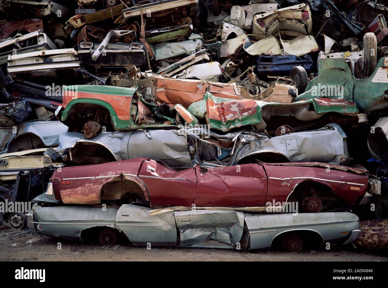 Flattened car bodies in a scrap metal yard. Once stripped of useful ...