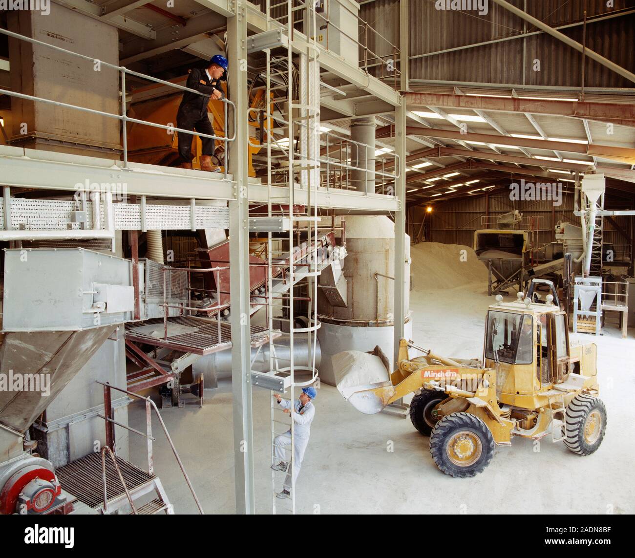 Cement production. Mechanical digger transporting powder components of ...