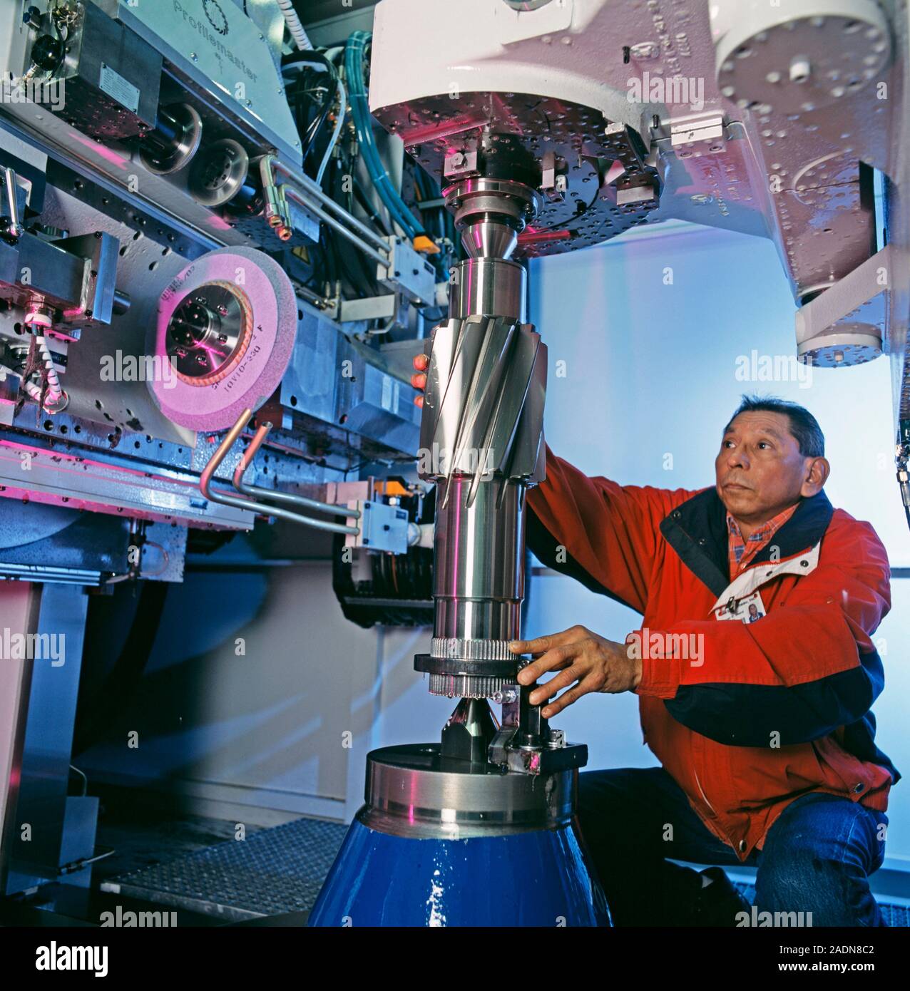 Gear. Worker with a gear for a wheel loader. This will be part of the ...