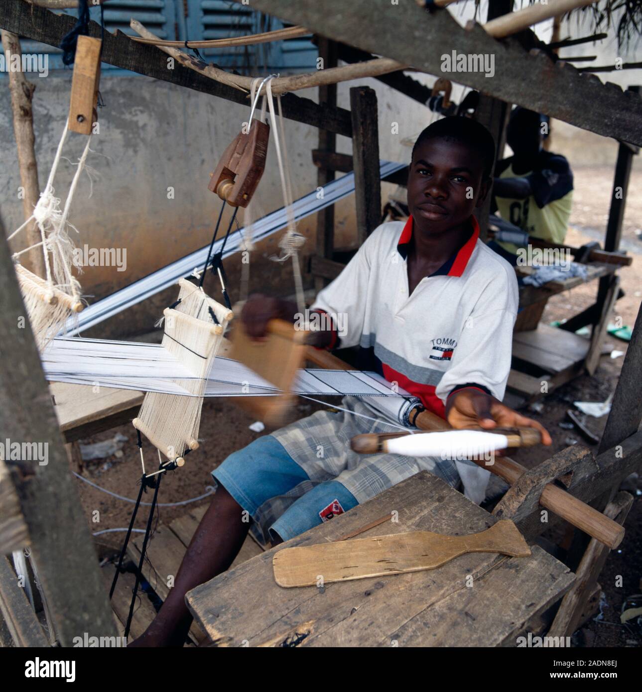 Kente cloth weaving. Young boy hand-weaving a traditional Asante ...