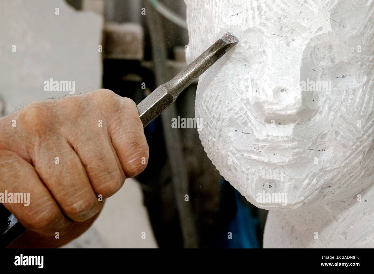 Sculpting. Sculptor using a chisel to form a human face from marble. He ...