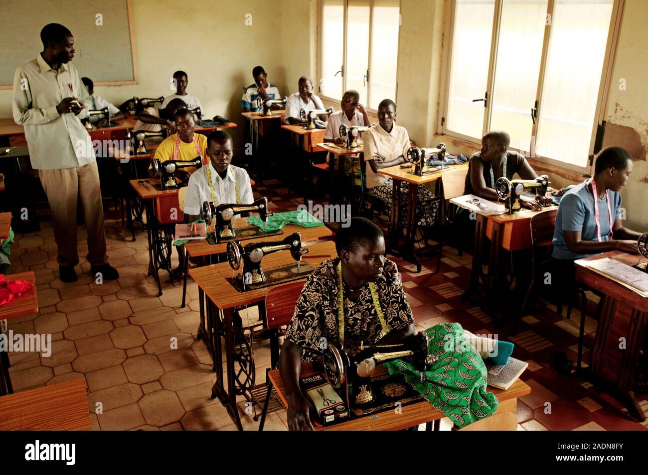 Sewing school. Students using sewing machines to makes clothes at a ...