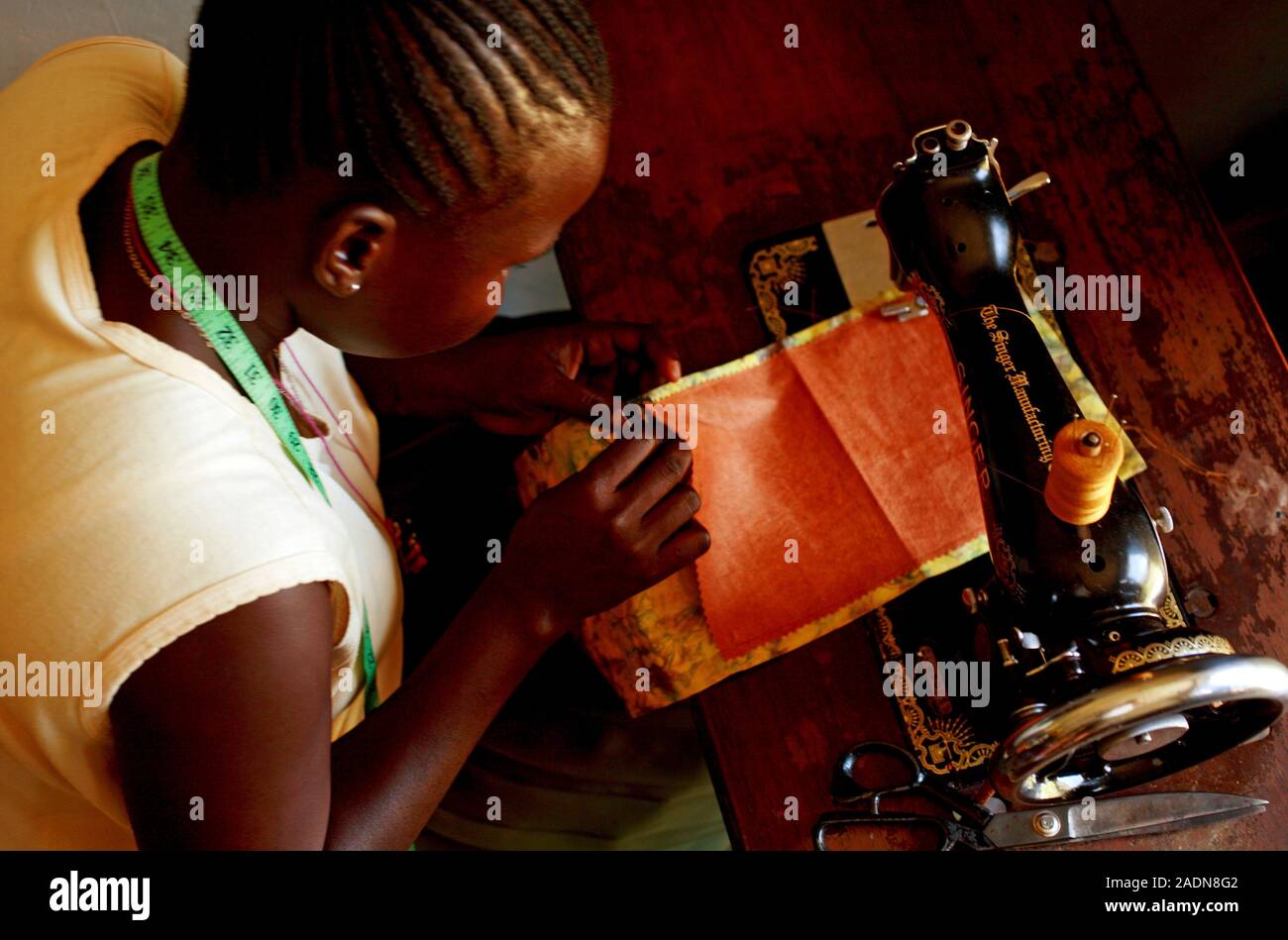 Using a sewing machine. Woman using a sewing machine to make an item of ...