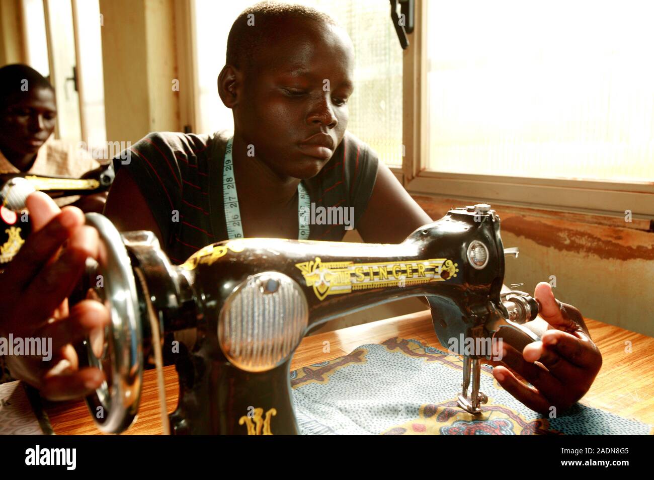 Using a sewing machine. Child using a sewing machine to make an item of ...